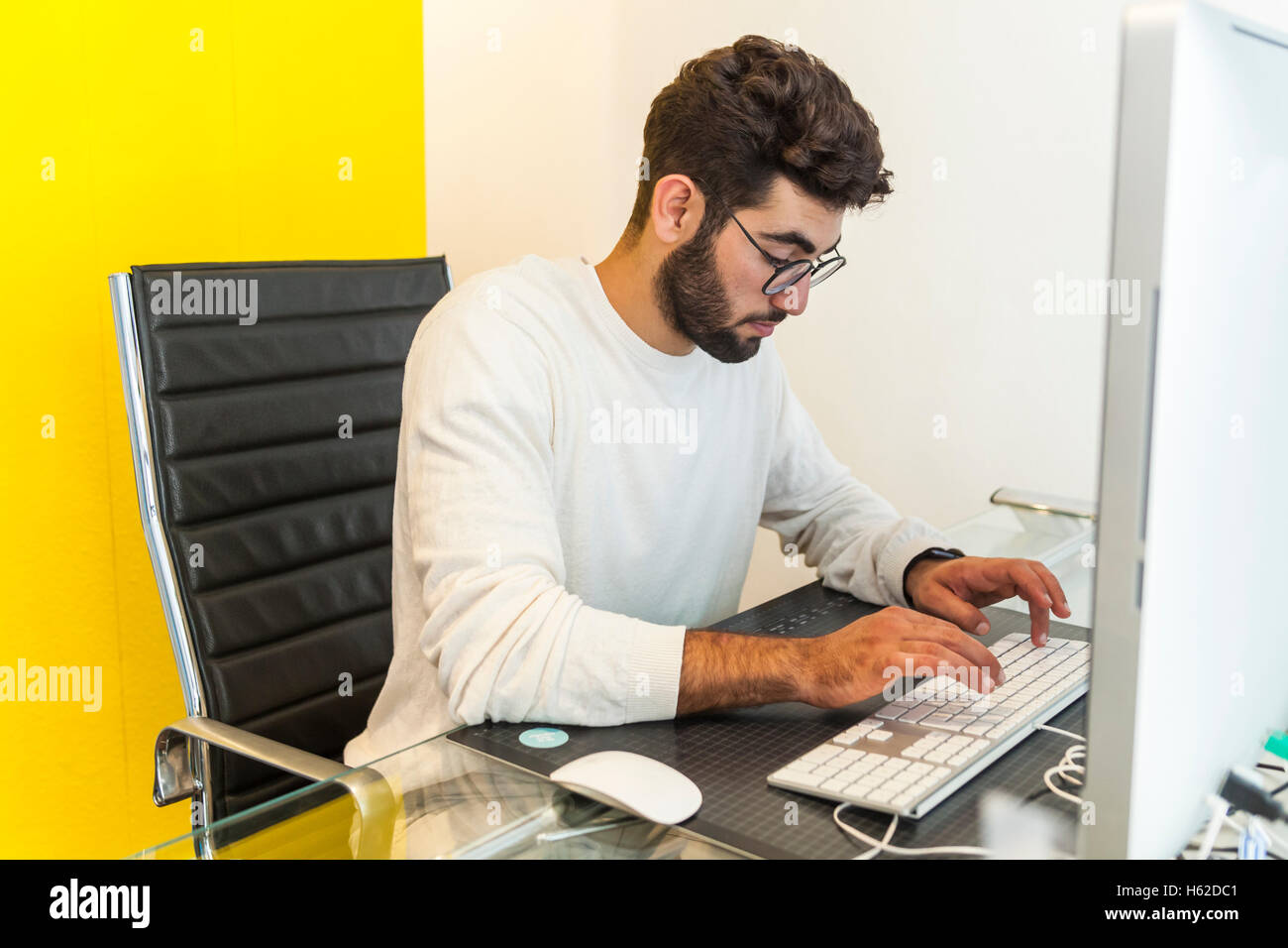 Young man working with computer in an office Stock Photo - Alamy