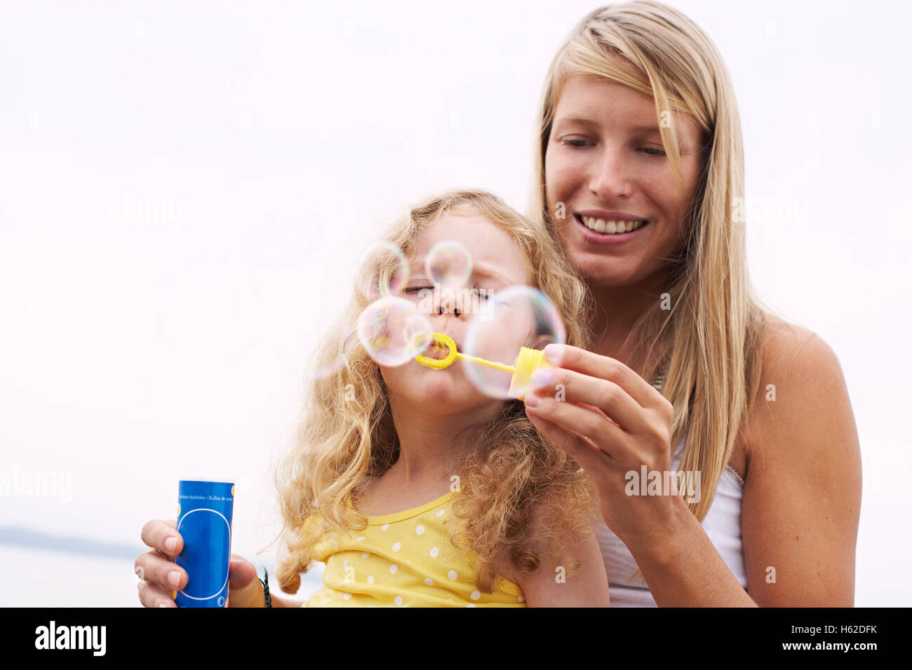 Mother and daughter blowing soap bubbles Stock Photo - Alamy
