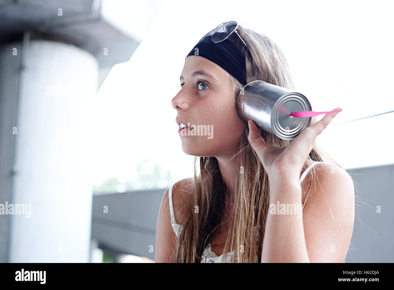 Girl listening at tin can phone Stock Photo - Alamy
