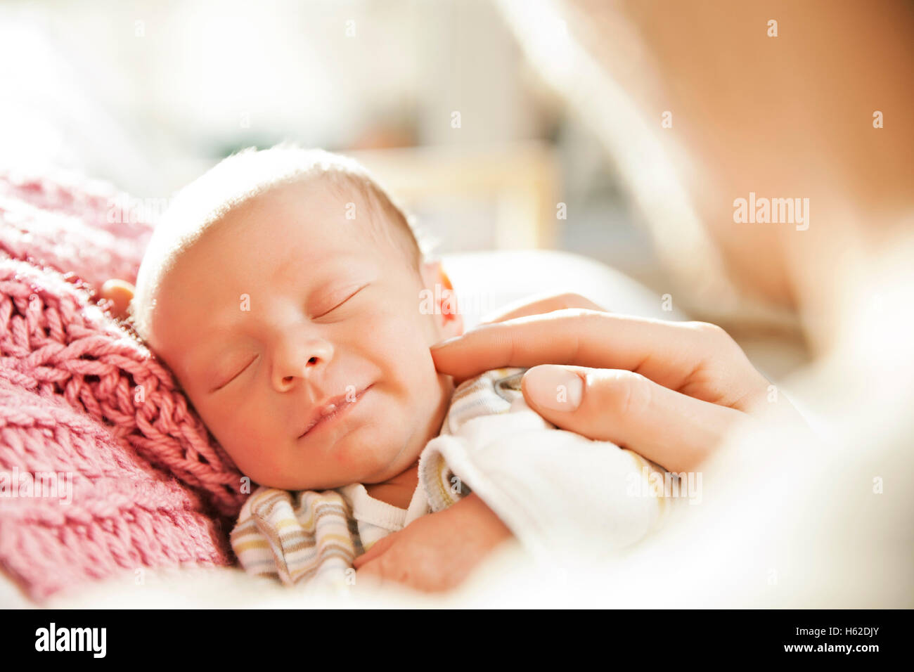 Sleeping newborn baby being touched by a hand Stock Photo - Alamy