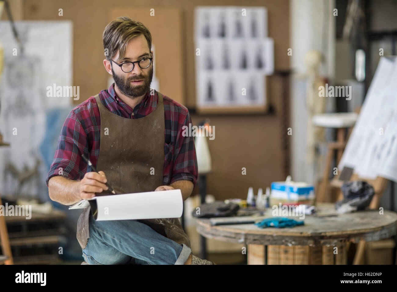 Artist in studio drawing in sketch book Stock Photo - Alamy