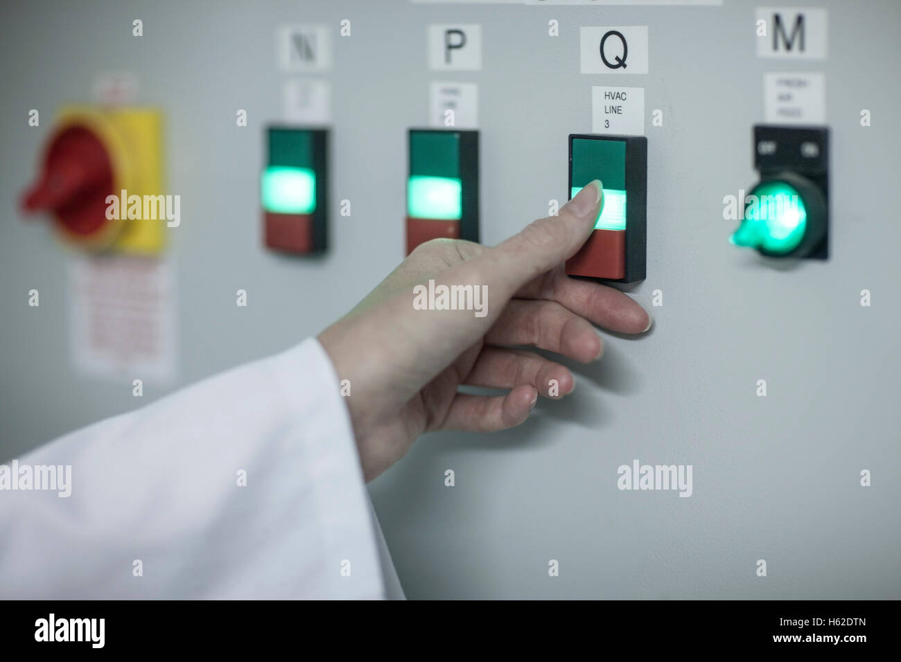 Close-up of woman switching on power switch in factory Stock Photo - Alamy