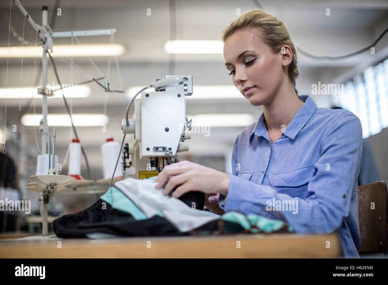 Seamstress working on sewing machine Stock Photo - Alamy