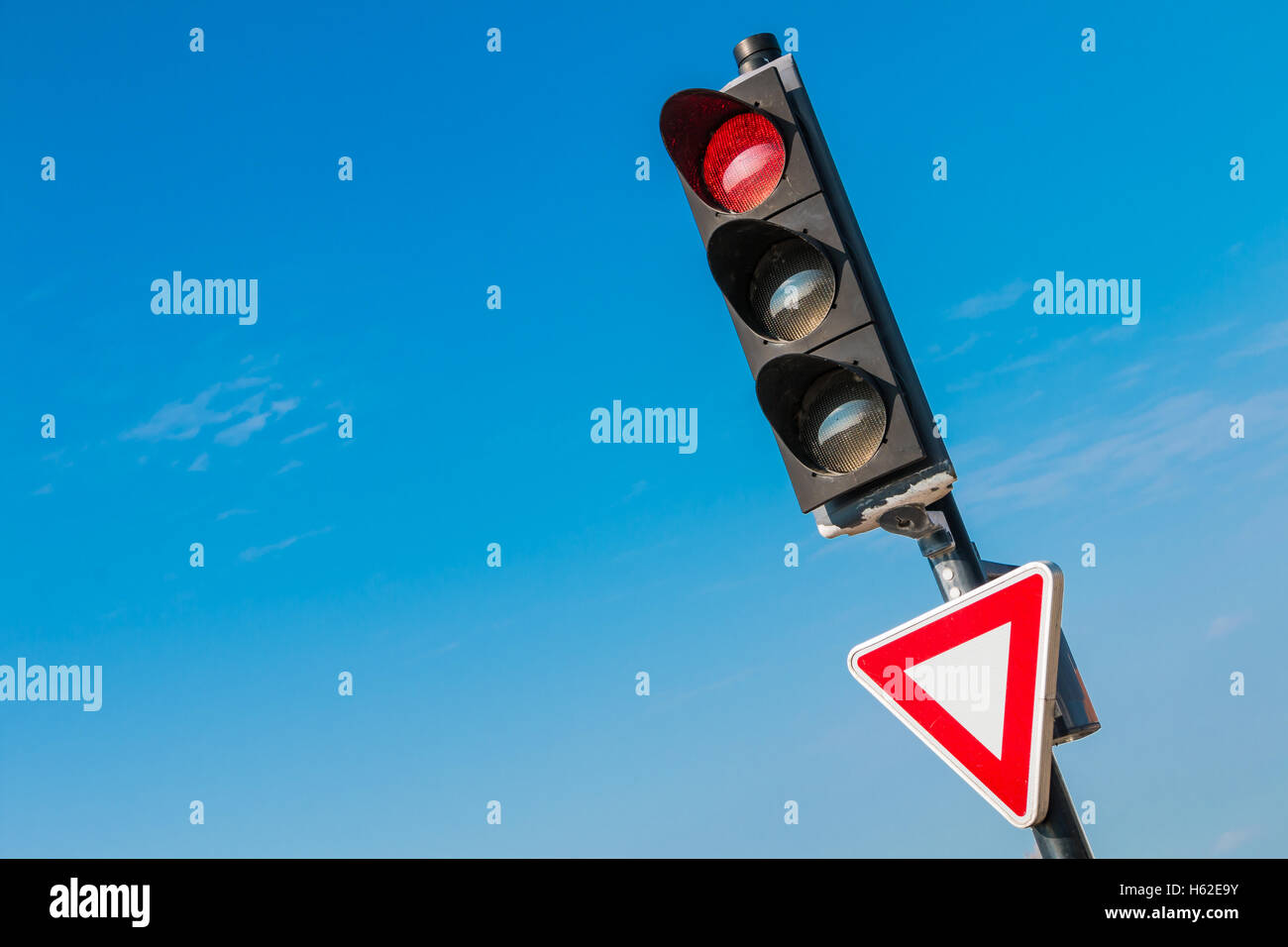 red traffic light with yield sign on blue sky Stock Photo - Alamy