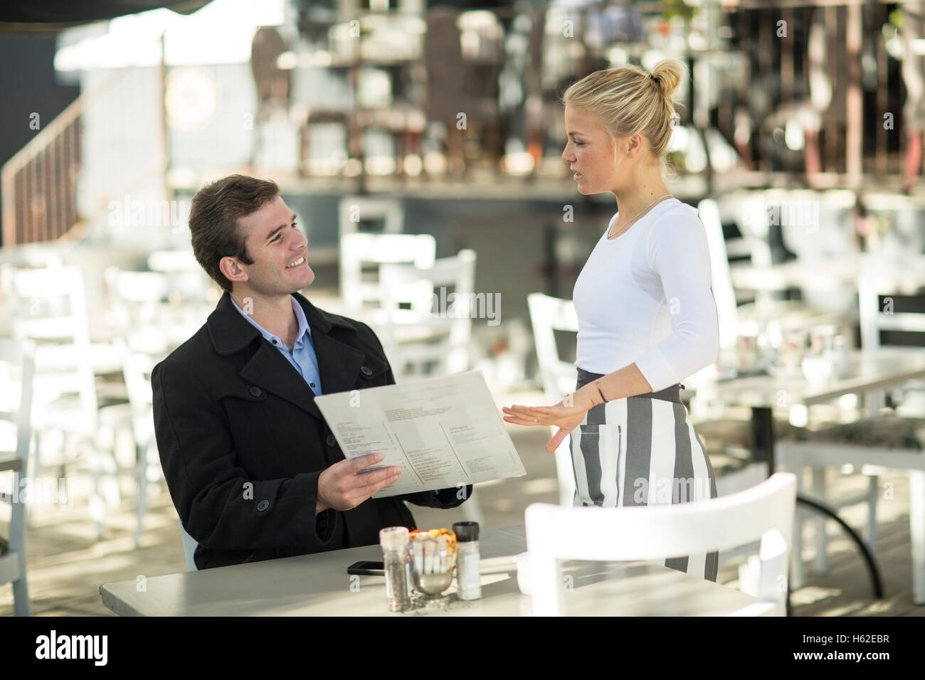 Man and waitress at outside restaurant Stock Photo - Alamy