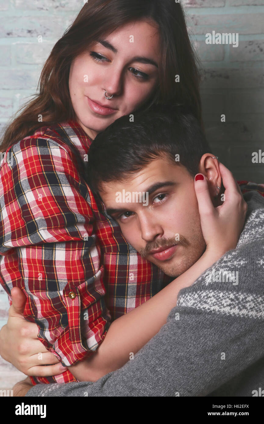 Young couple hugging at brick wall Stock Photo - Alamy