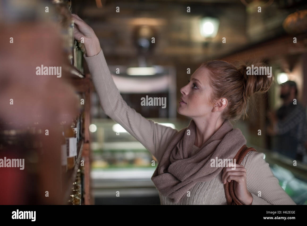Woman taking product from shelf in shop Stock Photo - Alamy