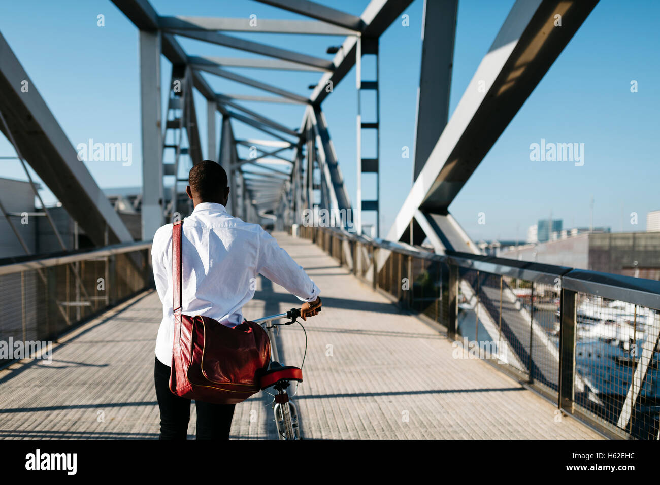 Man pushing bicycle on a bridge Stock Photo - Alamy