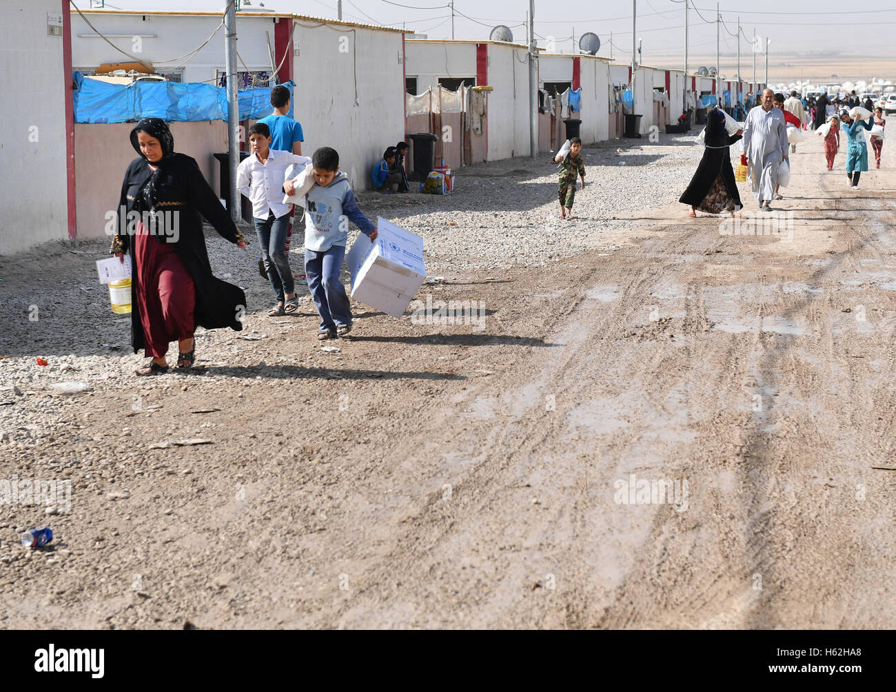 A family carries sacks of food which they received via food ...