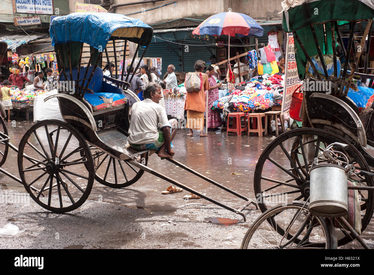 The hand pulled rickshaw man seating on his ricksh waiting for clients ...