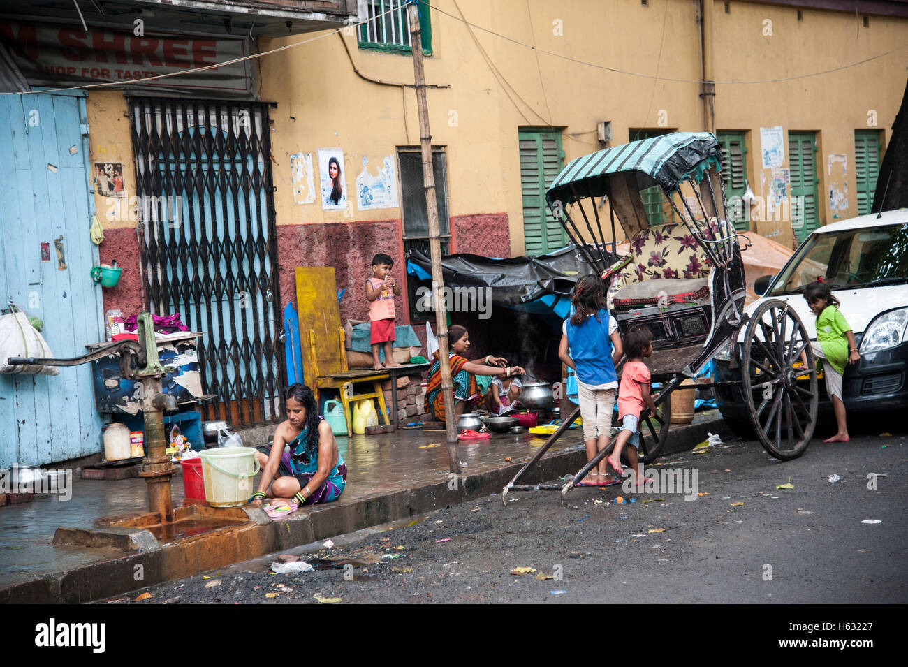 The hand pulled rickshaw and street life Woman bathing on a street of ...