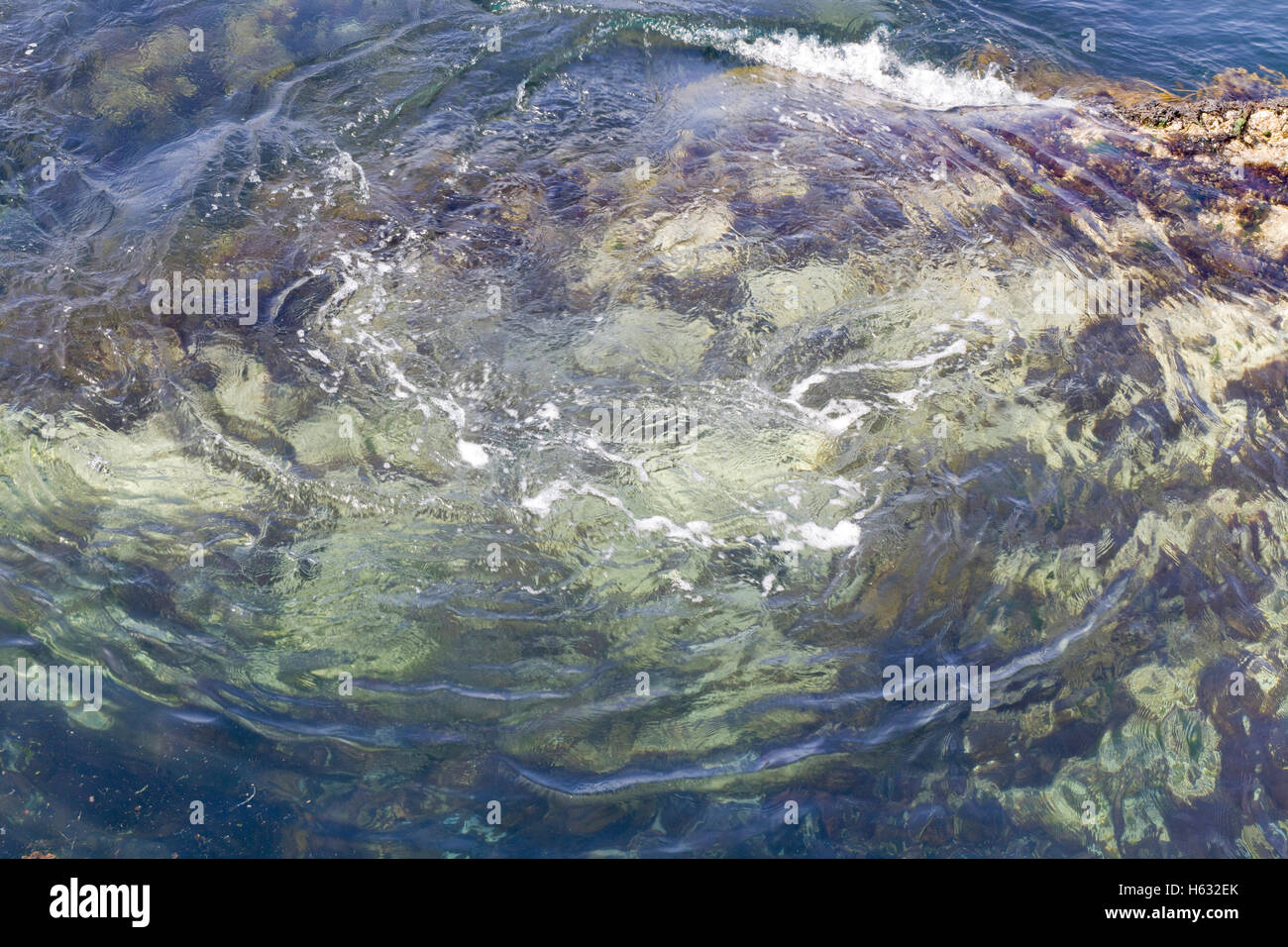 water swirling over rocks in the ocean Stock Photo - Alamy