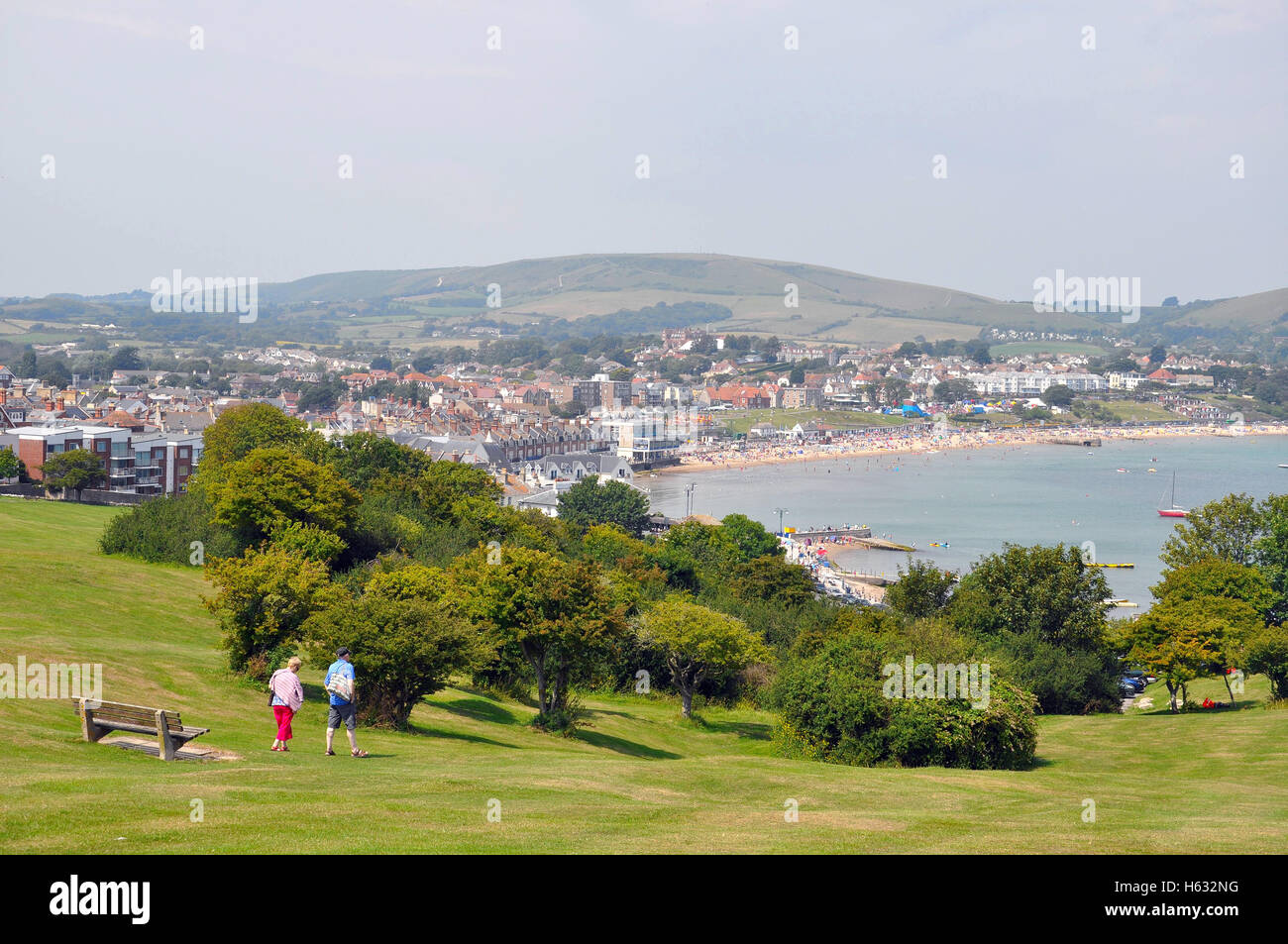 Couple walking on Ballard down looking across Swanage bay, Dorset ...