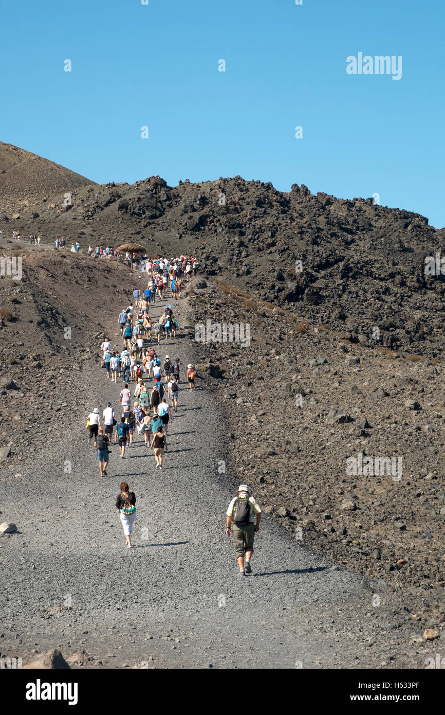 Tourists on their way up to the summit of the volcano which stands in ...