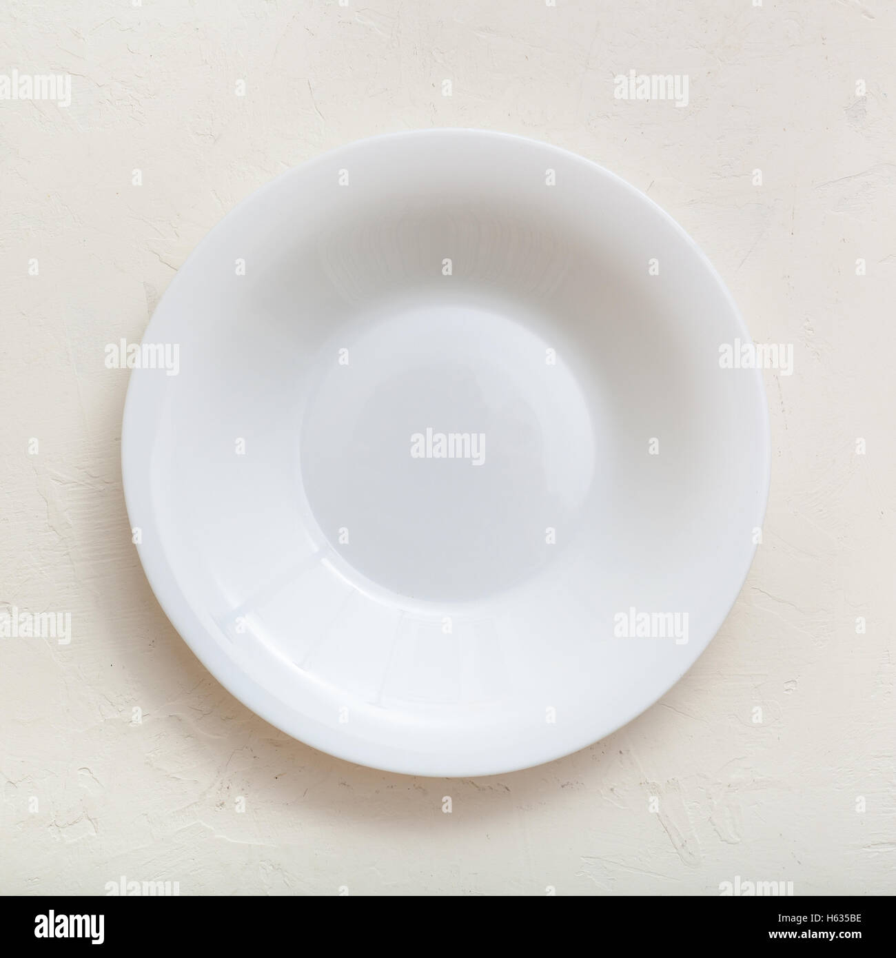 top view of white deep plate on plastering surface Stock Photo - Alamy