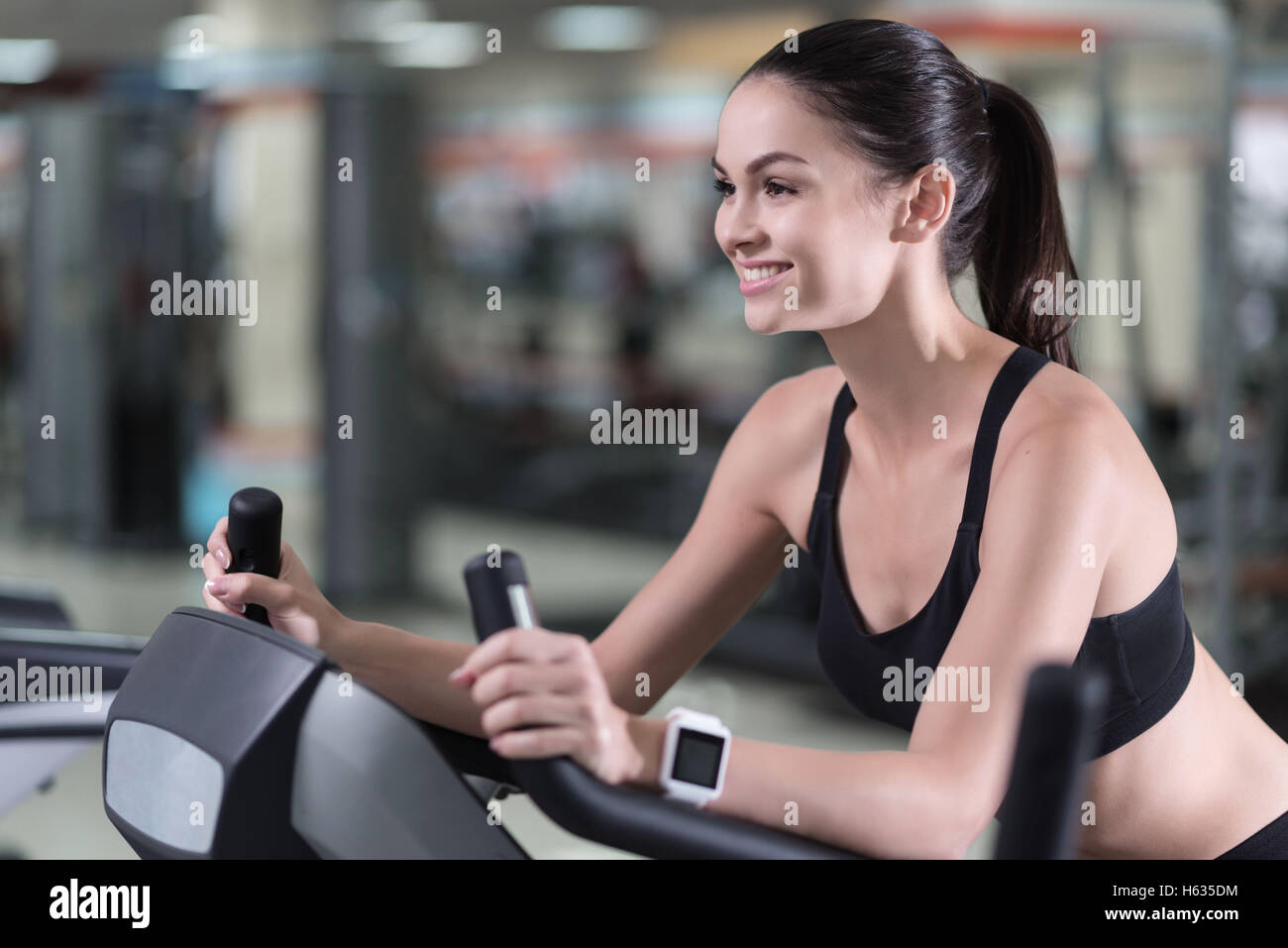 Smiling woman running on a treadmill Stock Photo - Alamy