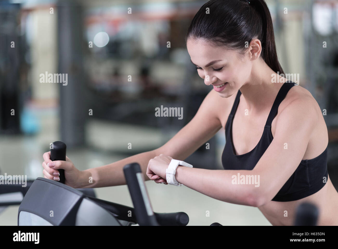 Active woman looking at smart watch in a gym Stock Photo - Alamy