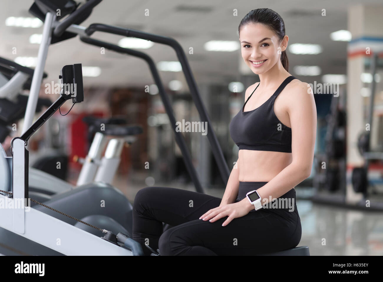 Smiling girl relaxing after workout in a gym Stock Photo - Alamy