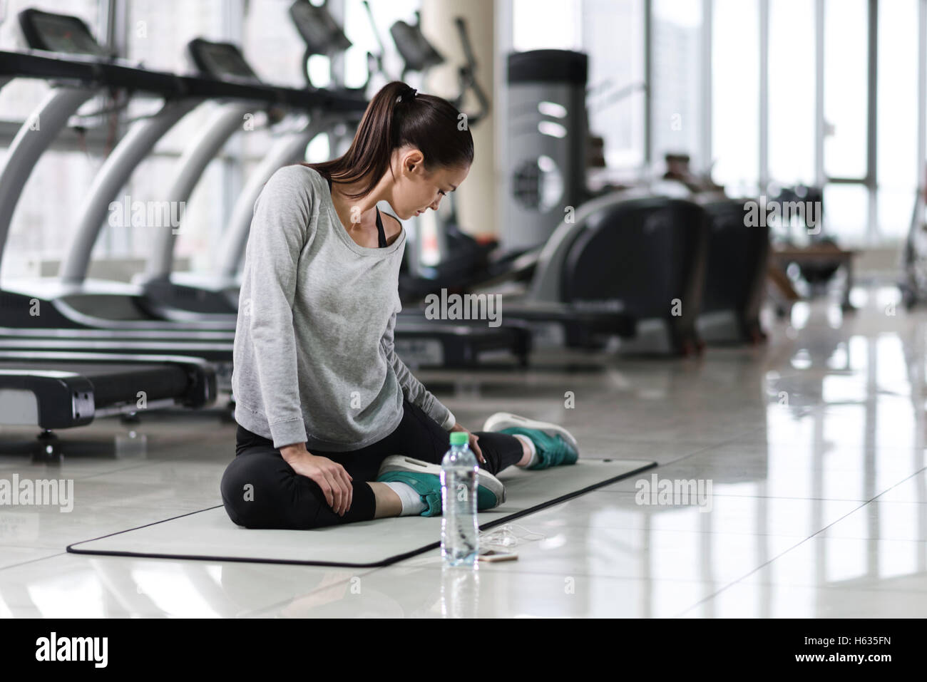 Young woman doing stretching after workout in a gym Stock Photo - Alamy