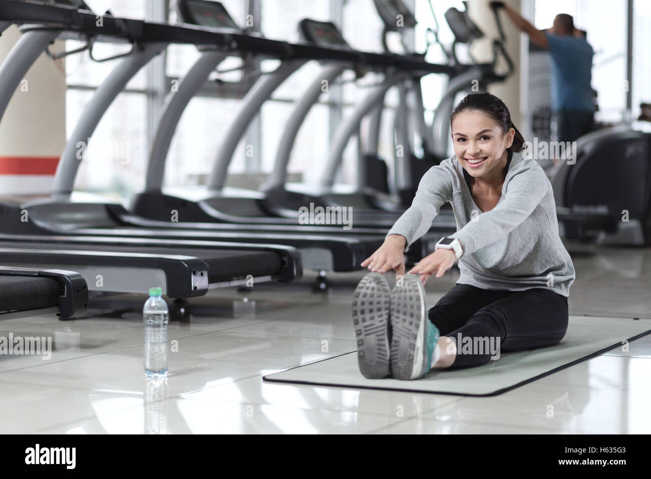 Smiling woman doing stretching exercises Stock Photo - Alamy