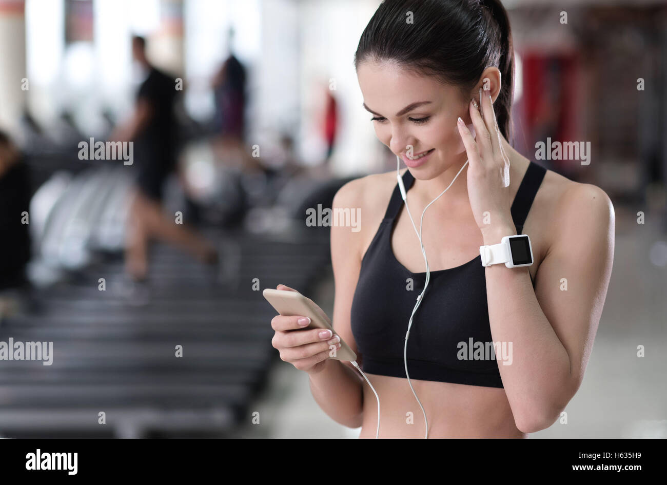 Joyful girl listening to music in a gym Stock Photo - Alamy