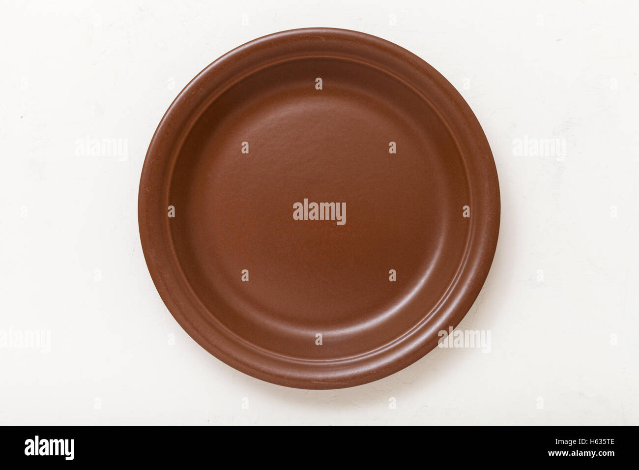 above view of one brown plate on white plastering board Stock Photo - Alamy