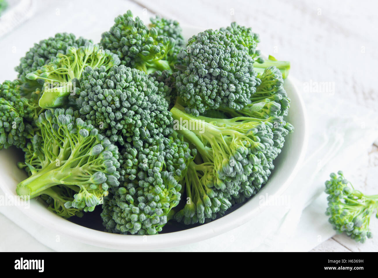 Healthy green organic raw uncooked broccoli in white bowl close up ...