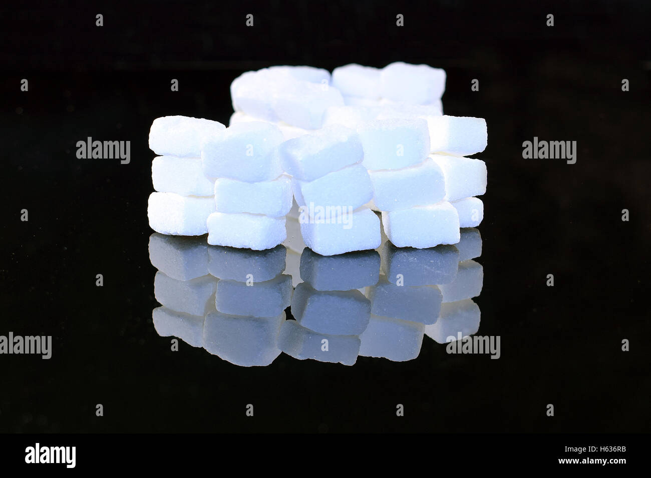Lump sugar cube isolated on black mirroring background Stock Photo - Alamy