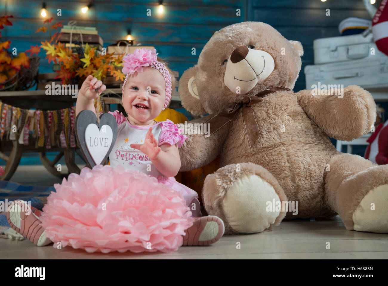 Happy one year old baby girl in autumn interior Stock Photo - Alamy