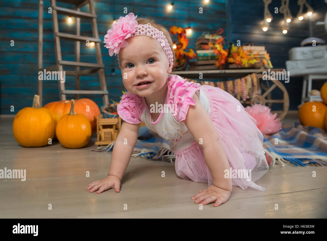 Happy one year old baby girl in autumn interior Stock Photo - Alamy