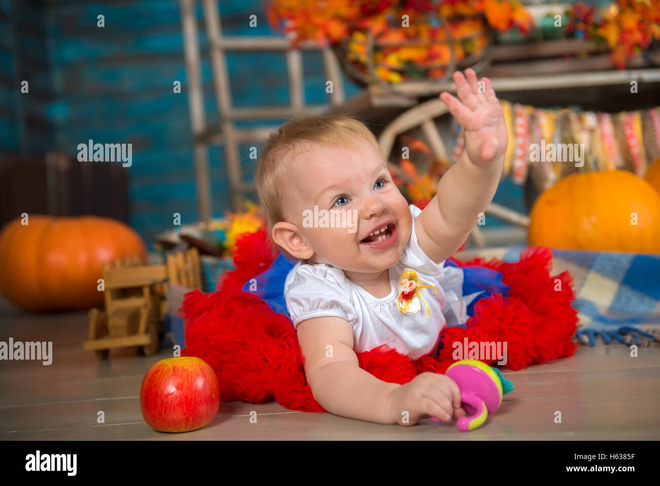Happy one year old baby girl in autumn interior Stock Photo - Alamy