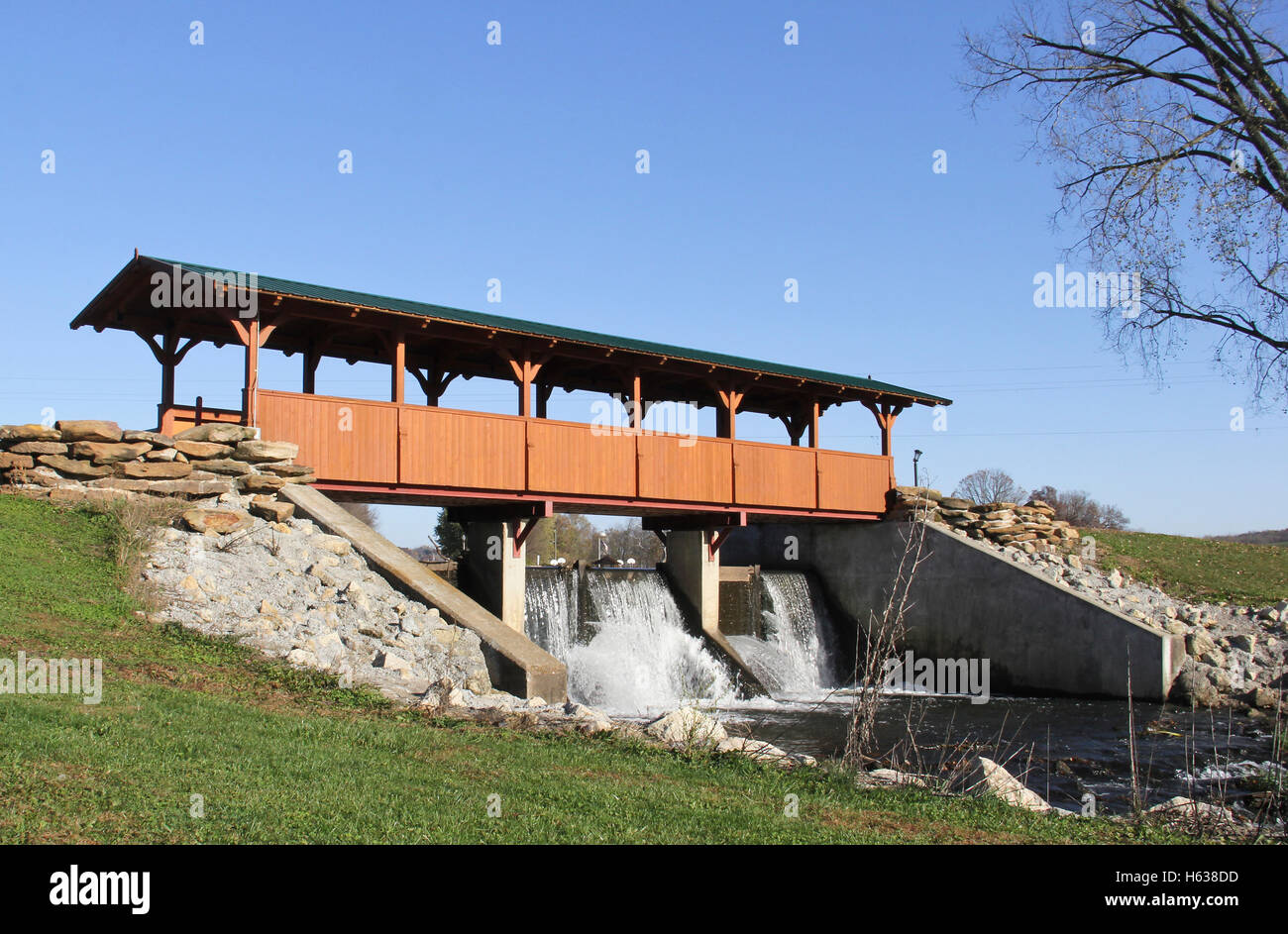 Wooden covered bridge dam with a blue sky background Stock Photo - Alamy