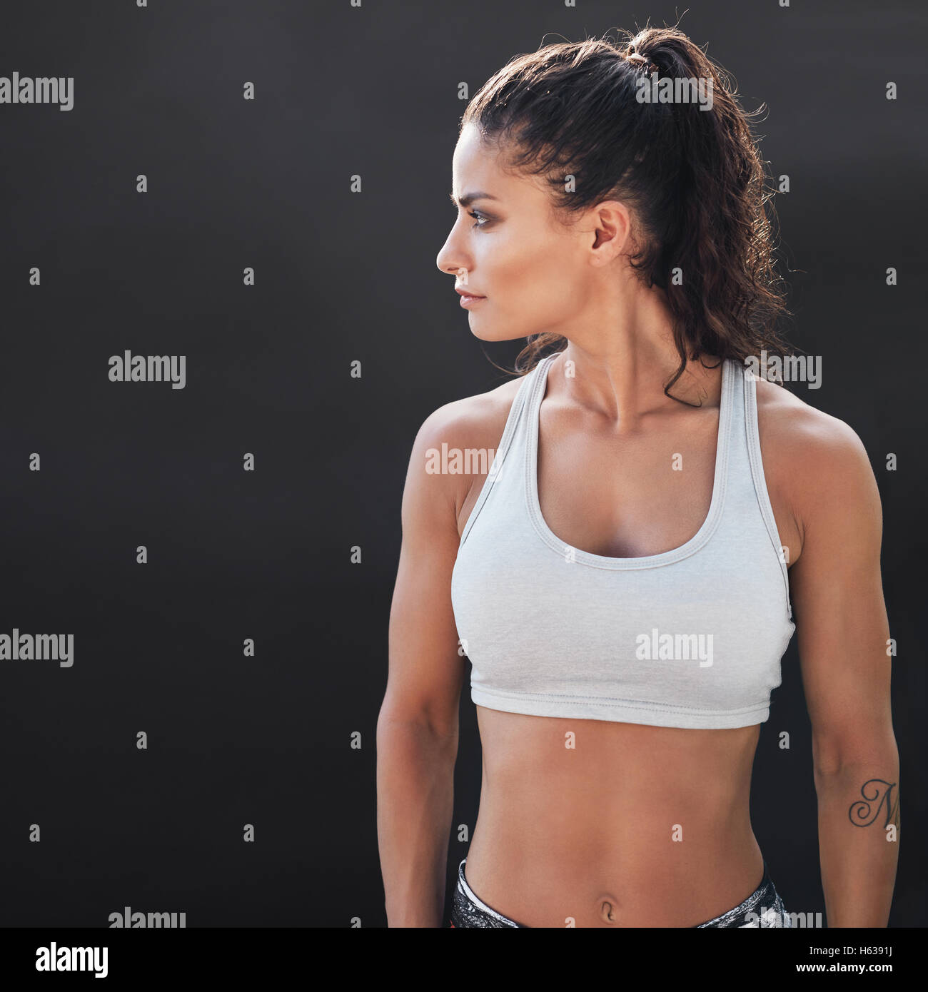 fitness young woman in sportswear standing on black background. Slim ...