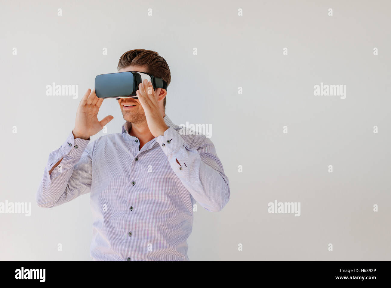 Shot of young man in virtual reality headset looking at the objects ...