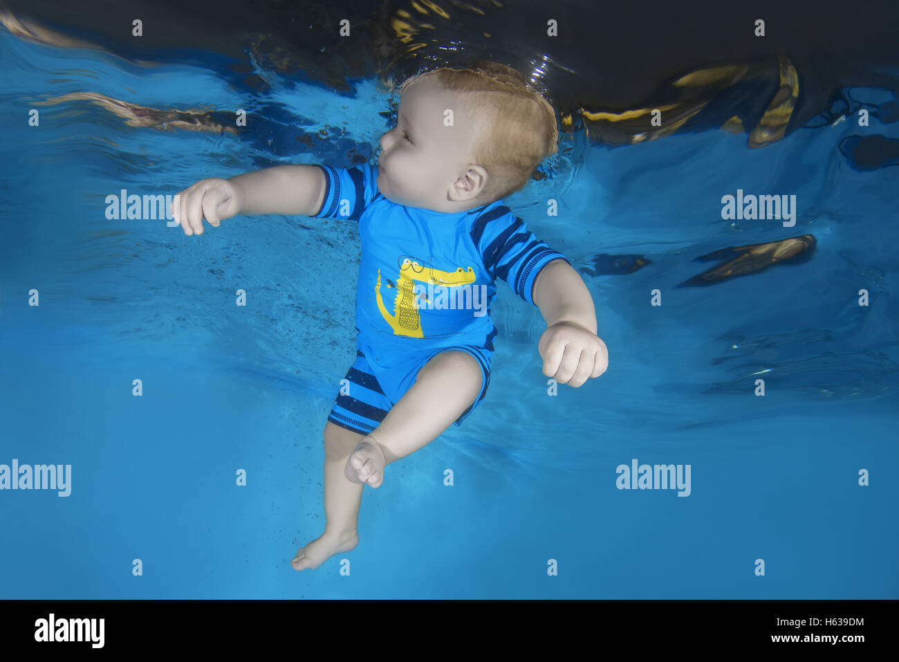 The little boy in overalls swims underwater in swimming pool Stock ...