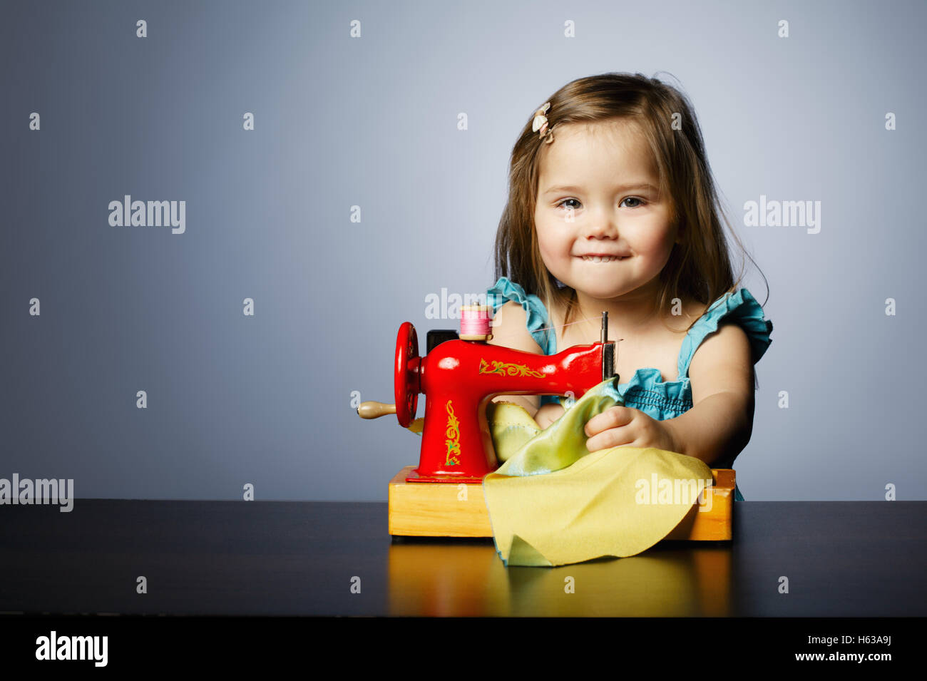 little girl is playing with sewing machine Stock Photo - Alamy