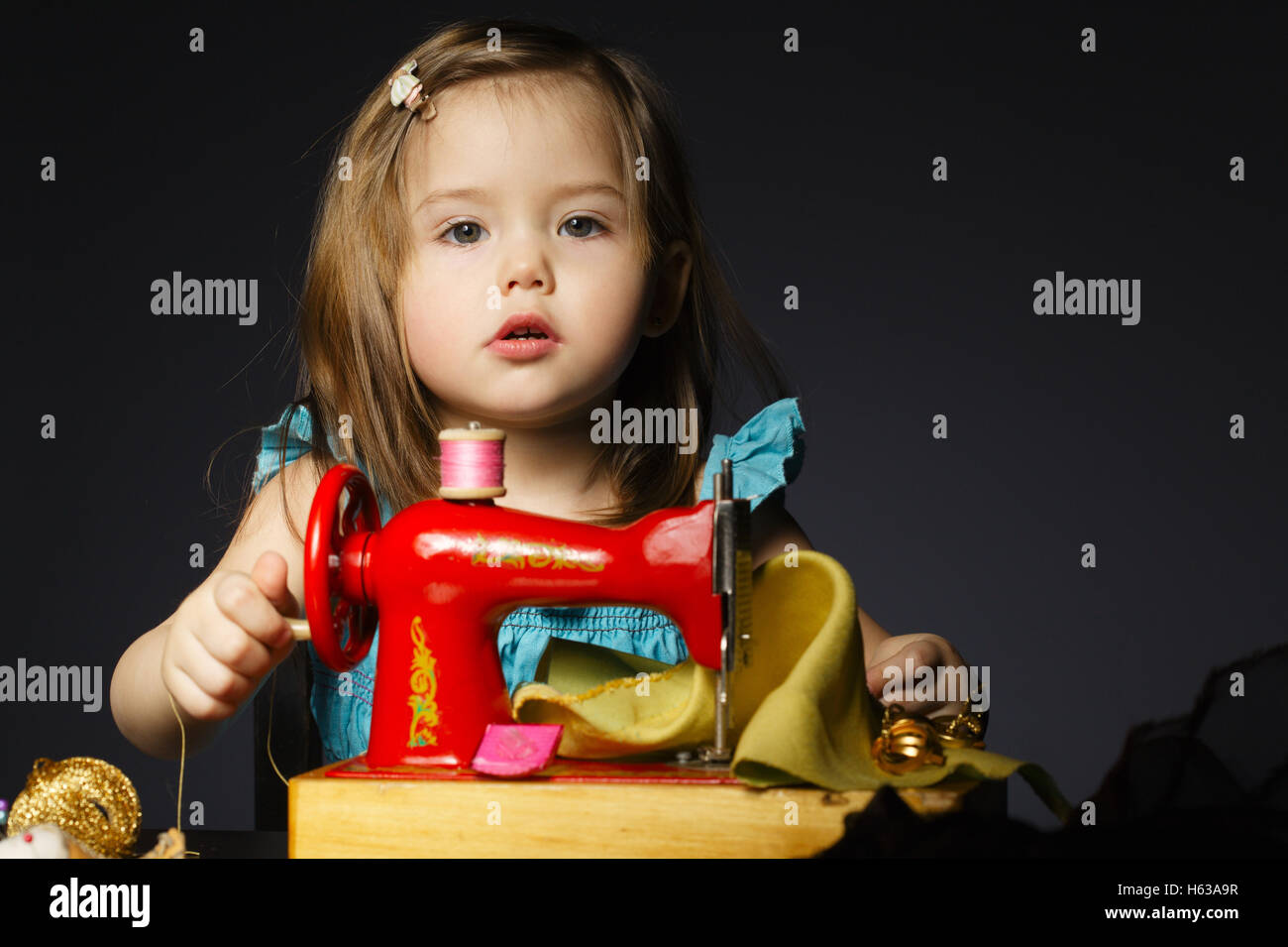 little girl is playing with sewing machine Stock Photo - Alamy