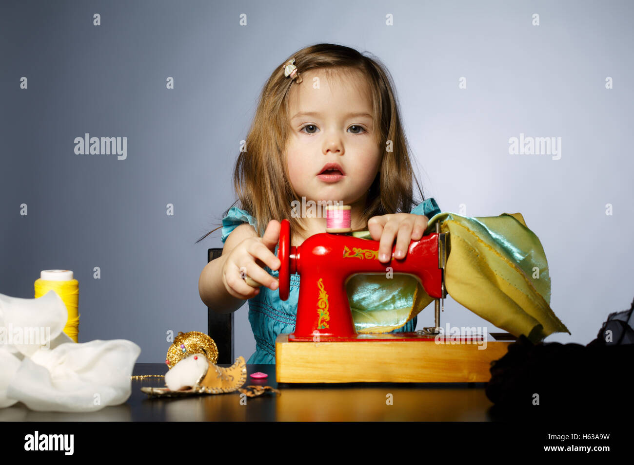 little girl is playing with sewing machine Stock Photo - Alamy