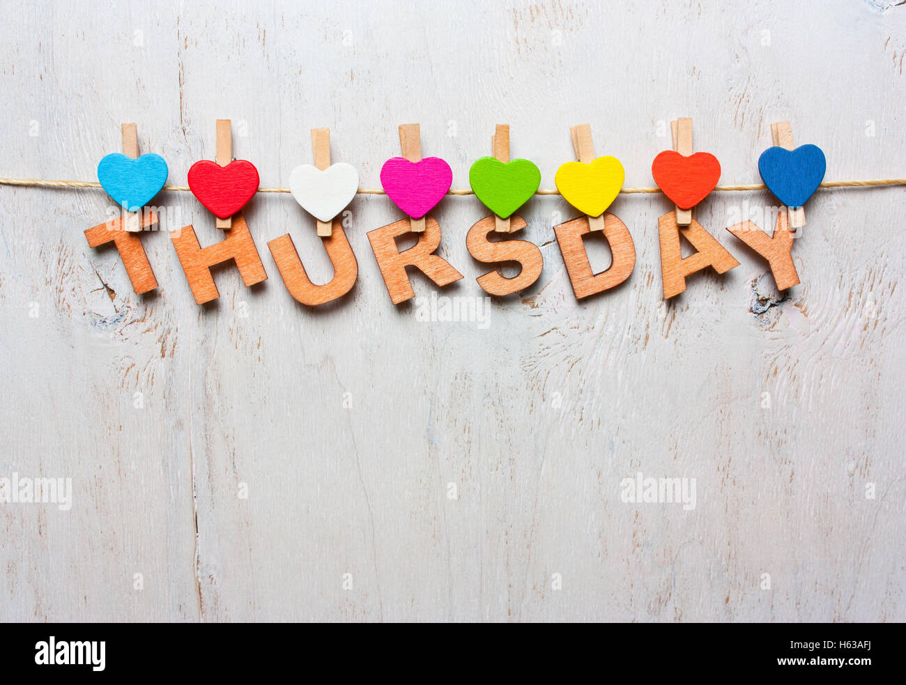 word Thursday from wooden letters with colored clothespins on a white ...