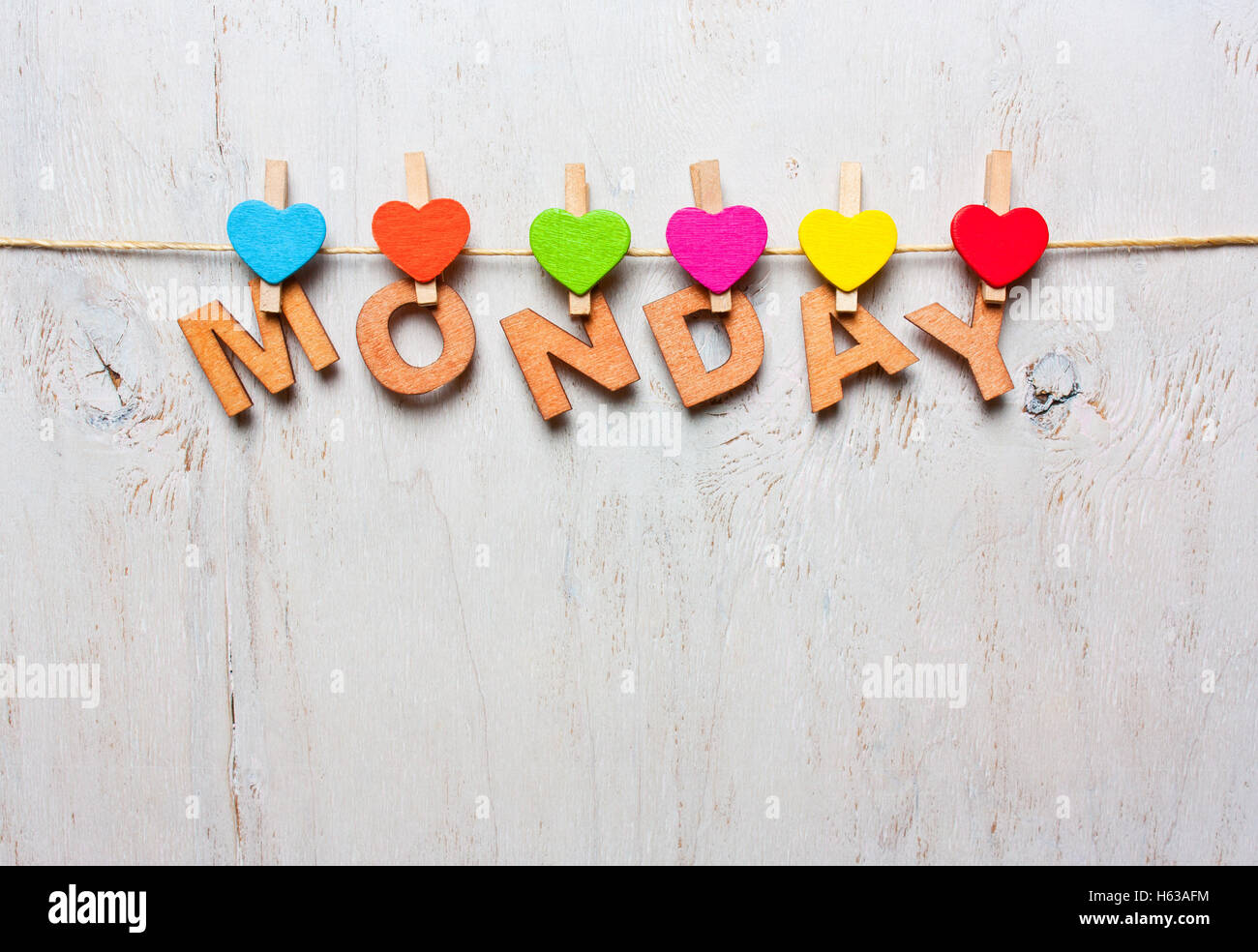 word Monday from wooden letters with colored clothespins on a white ...