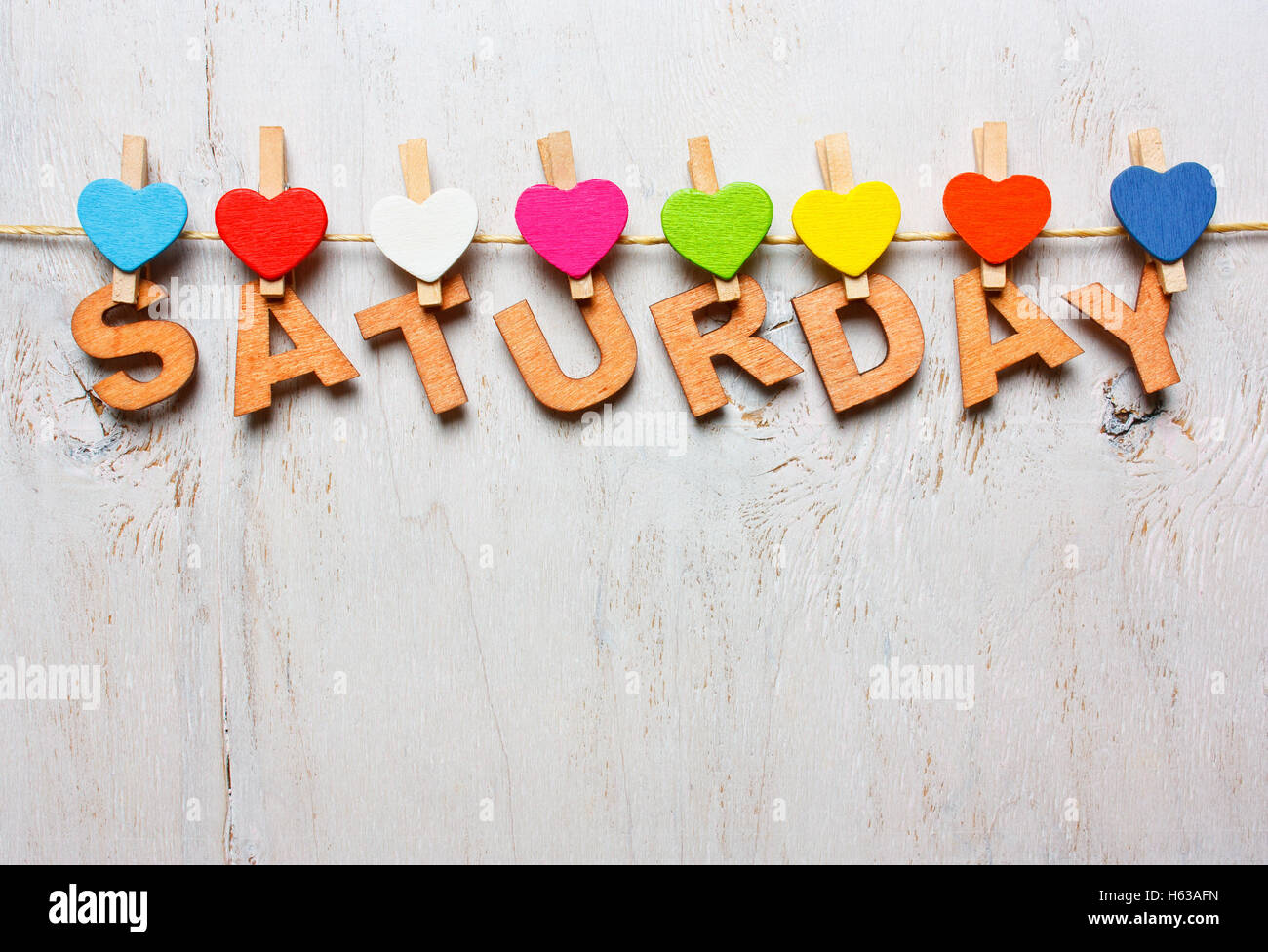 Saturday word from wooden letters with colored clothespins on a white ...