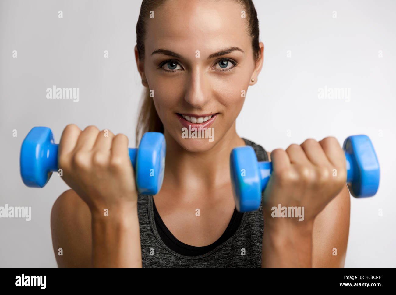 Young fitness woman making exercises with dumbbells Stock Photo - Alamy