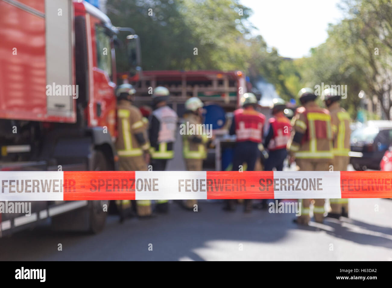 Team of firefighters by firetruck on accident location Stock Photo - Alamy