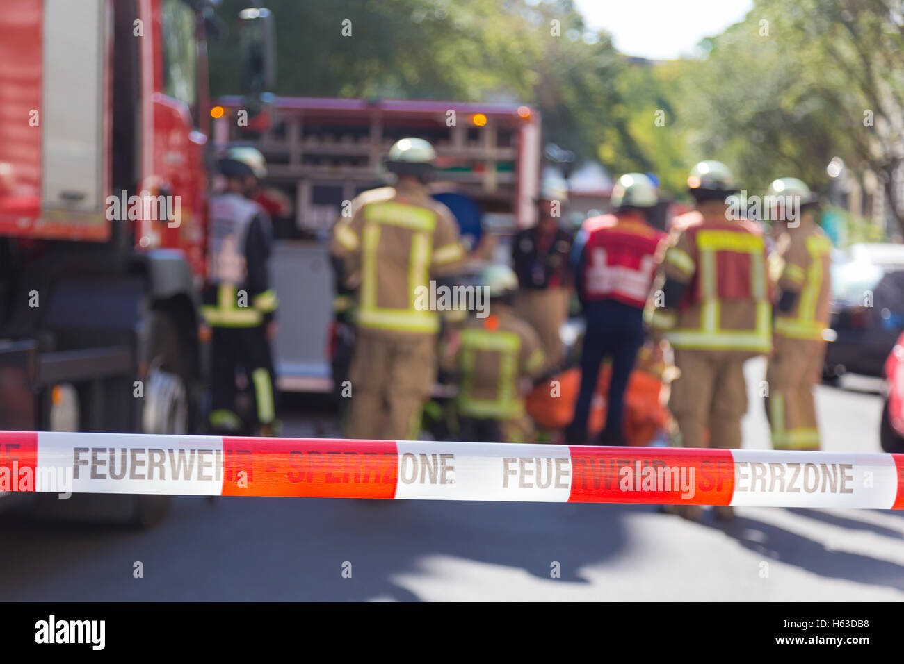 Team of firefighters by firetruck on accident location Stock Photo - Alamy