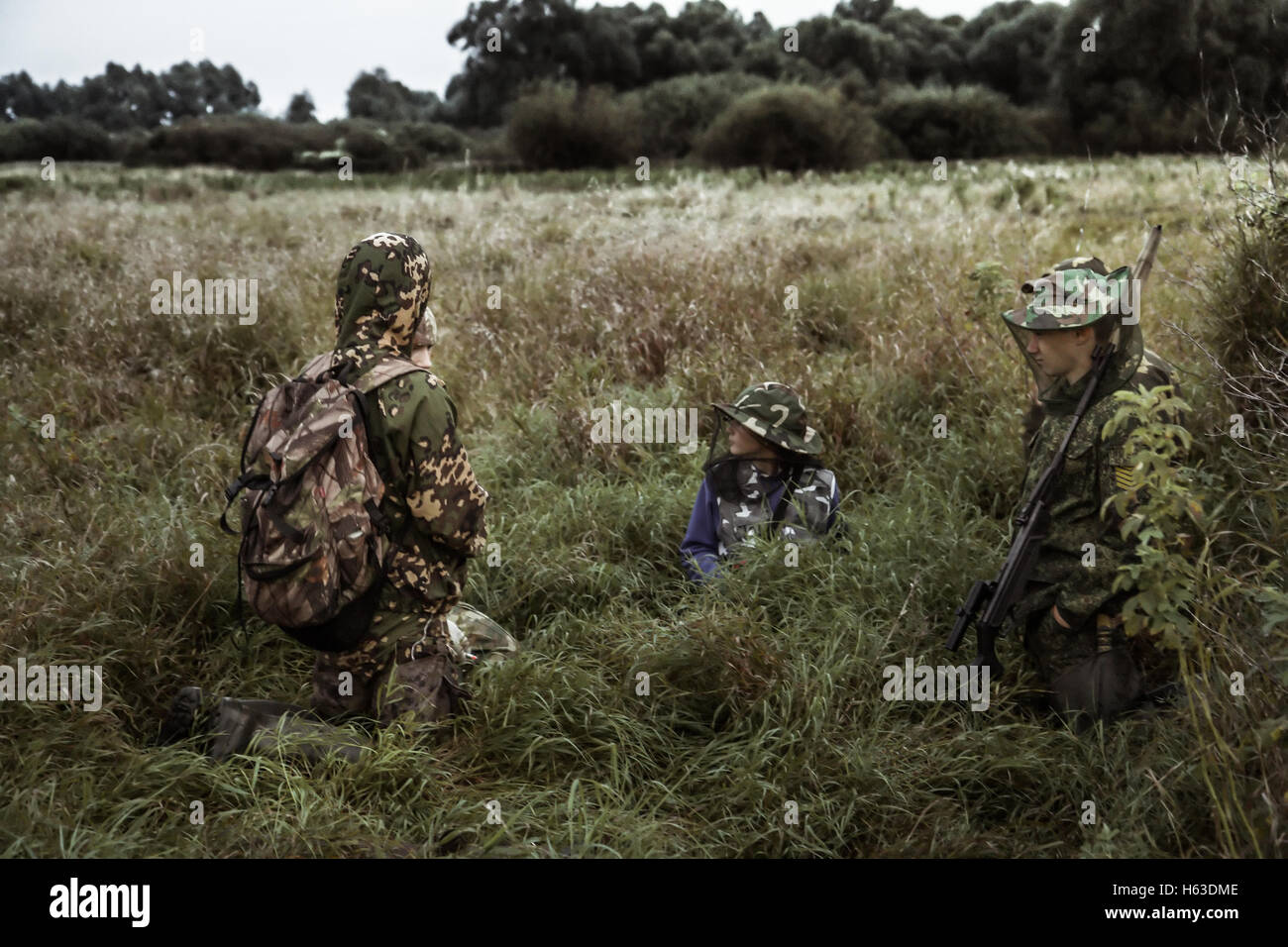 Dramatic hunting scene with group of hunters in rural field in ...