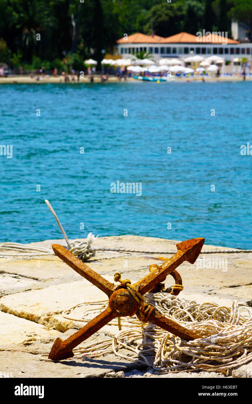 An anchor in the fishing harbor, and a beach in the background, in the ...
