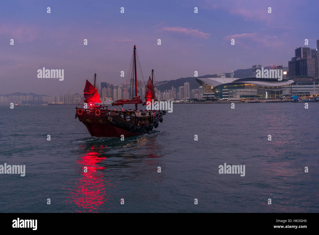 Traditional red junk boat in the Victoria Harbor in Hong Kong at sunset - 2 Stock Photo - Alamy