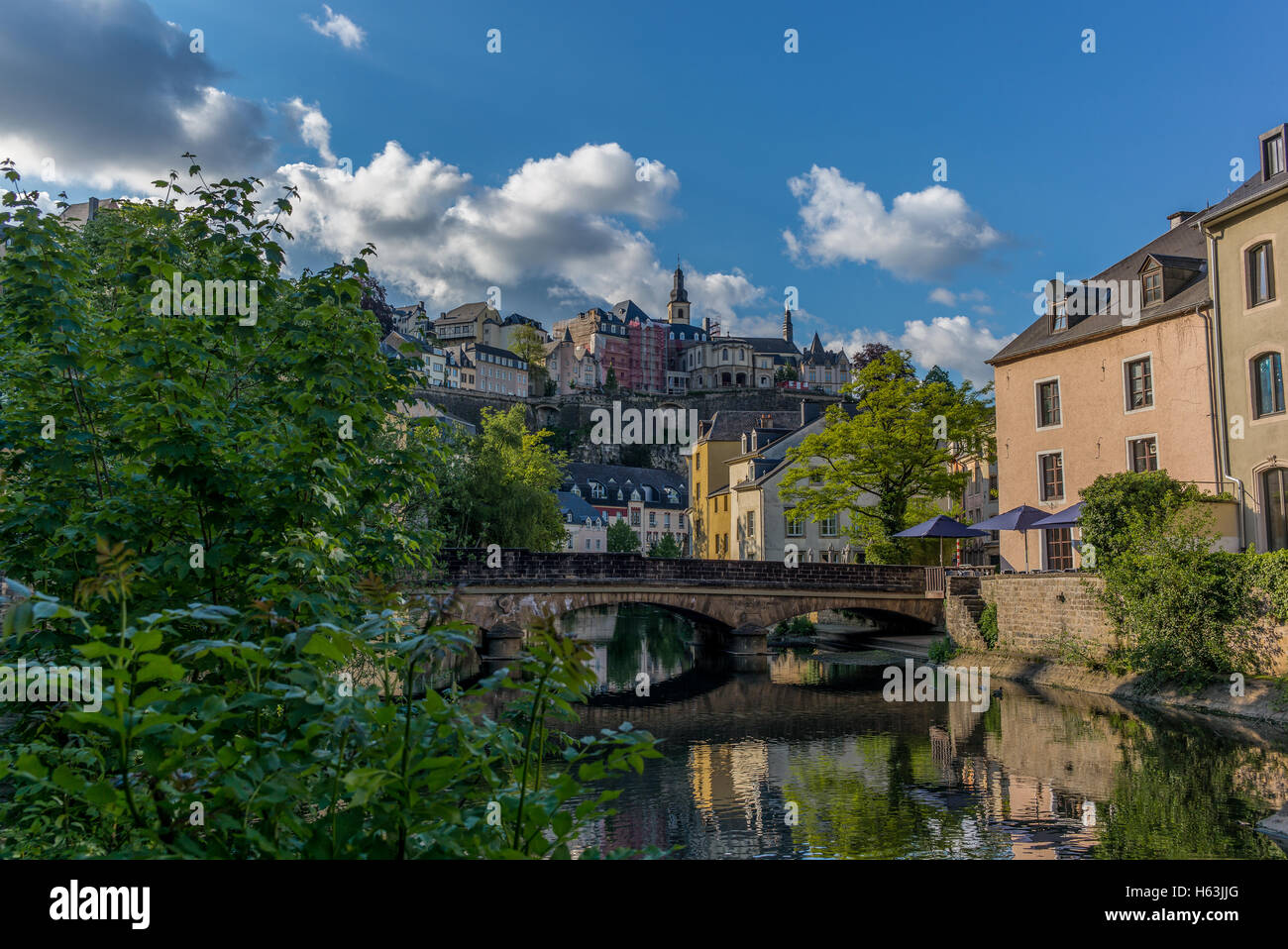 Stone bridge reflecting in the Alzette river in the city of Luxembourg ...