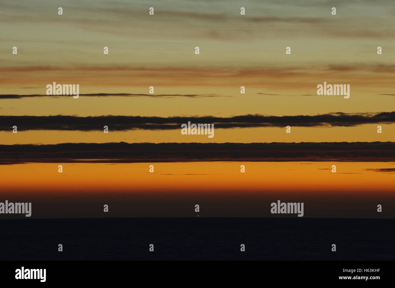 Stripy clouds after a gorgeous sunset, navigation beacon just visible ...