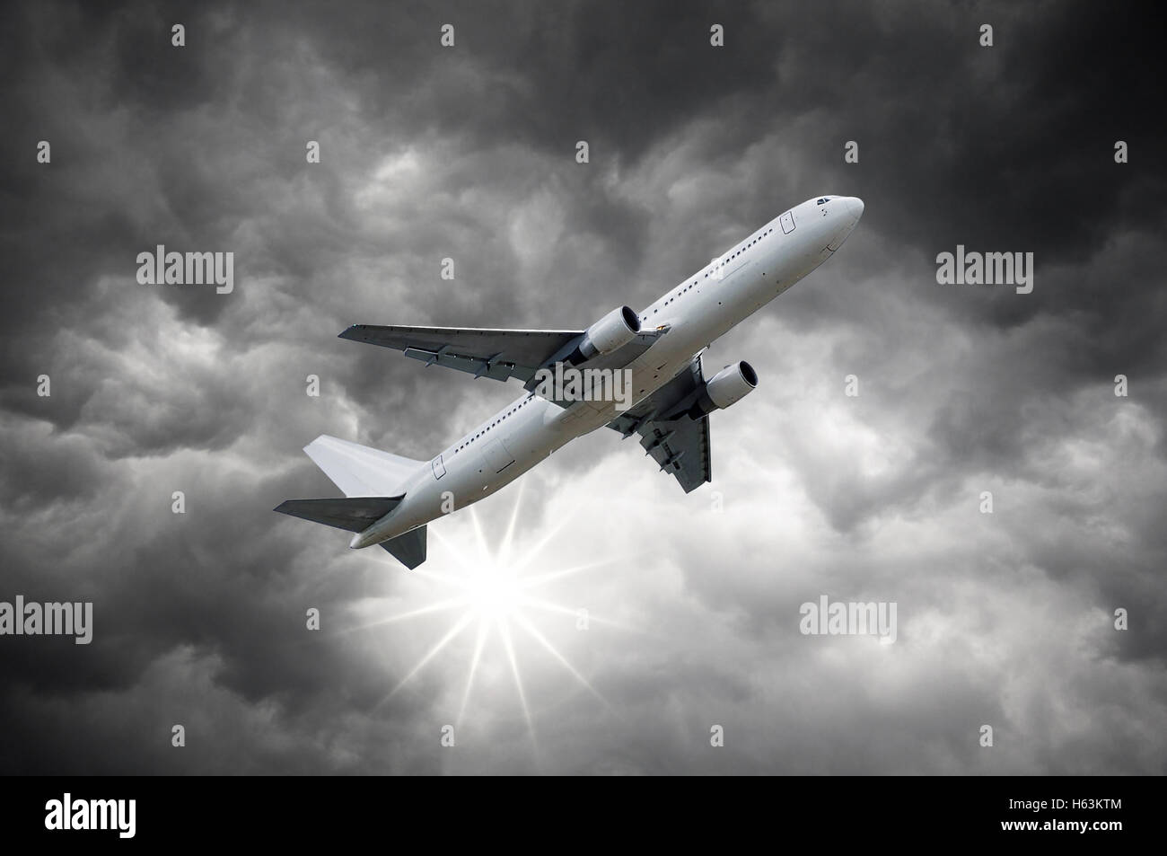 Airplane above the Sun shining from dark clouds of storm sky Stock ...